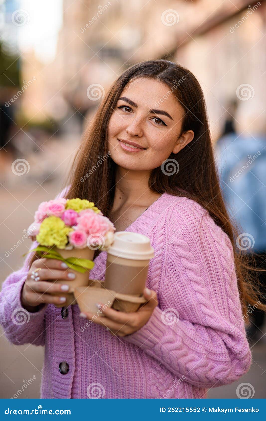 Smiling Woman Holds Flower Arrangement In Small Pot And Paper Cup Of