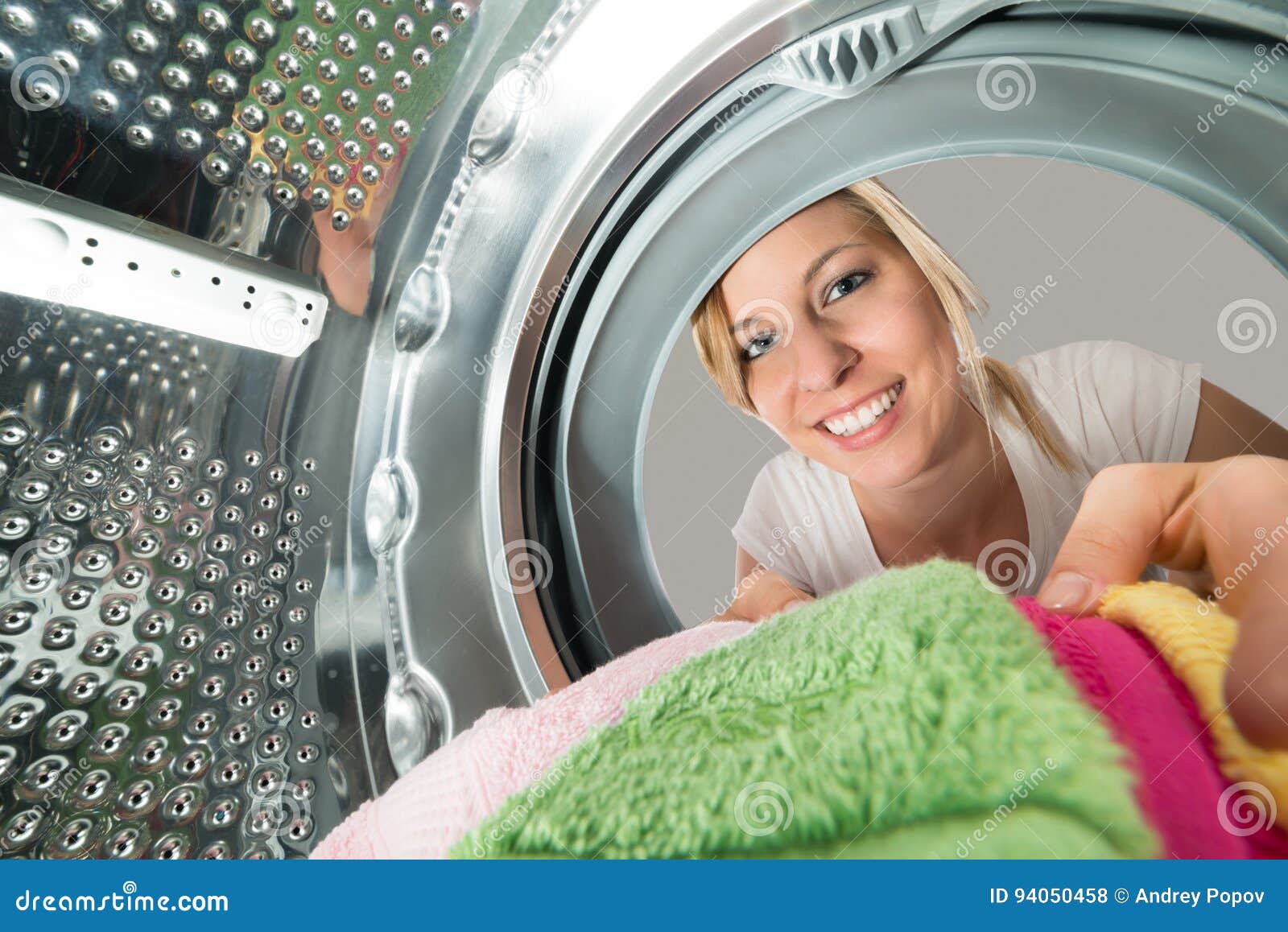 Smiling Woman Inserting Clothes in Washing Machine Stock Photo - Image ...