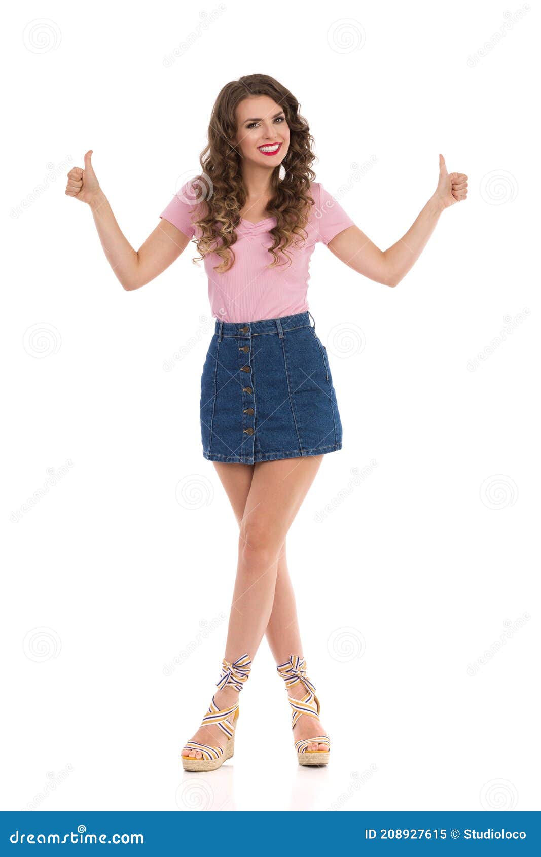 Smiling Woman In Jeans Mini Skirt And Wedge Shoes Is Showing Thumbs Up
