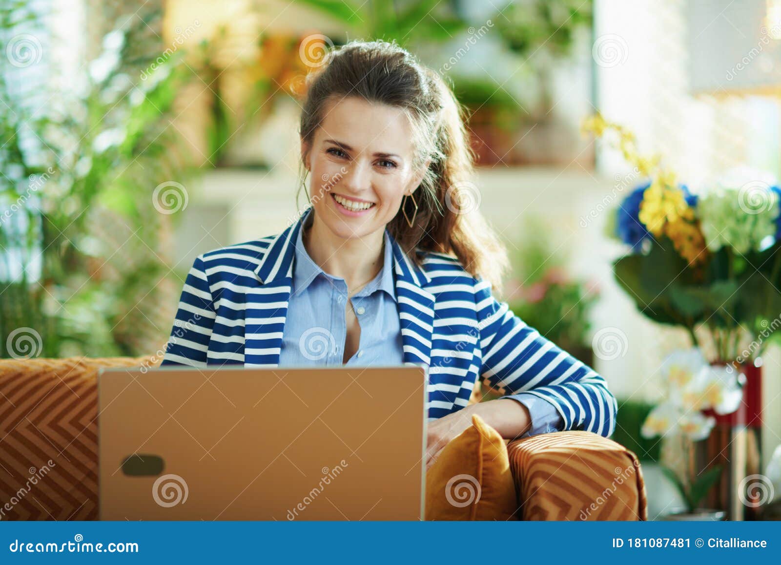 Smiling Woman With Laptop In Modern Living Room In Sunny Day Stock