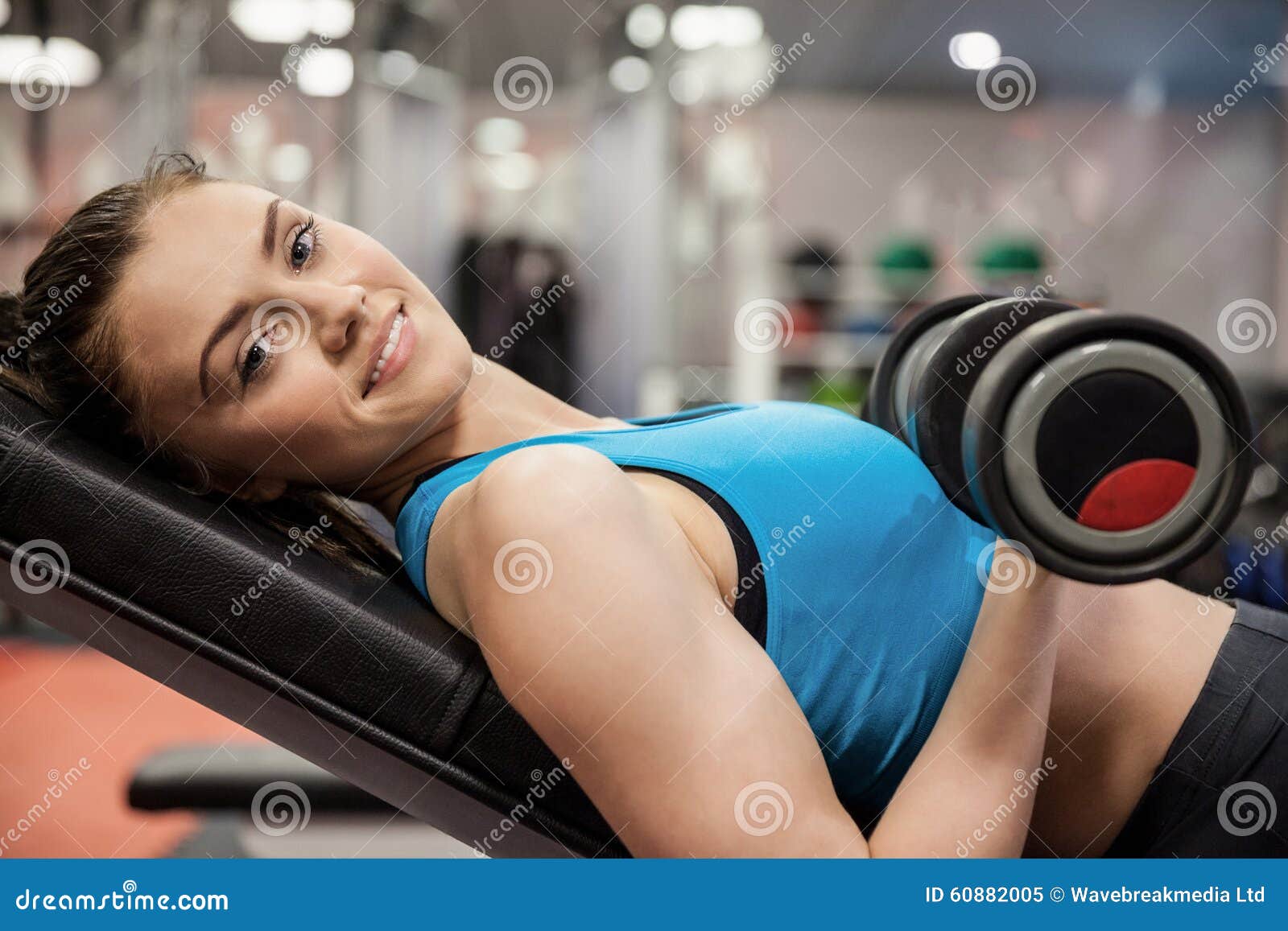 Smiling Woman Lifting Dumbbell while Lying Down Stock Image - Image of ...