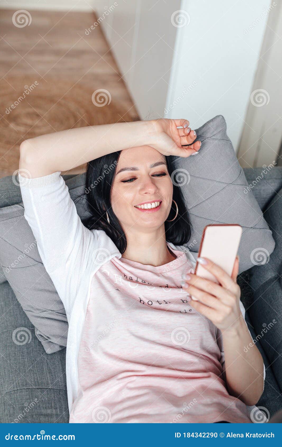 Smiling Woman Lying and Using Mobile Phone at Home Stock Photo - Image ...