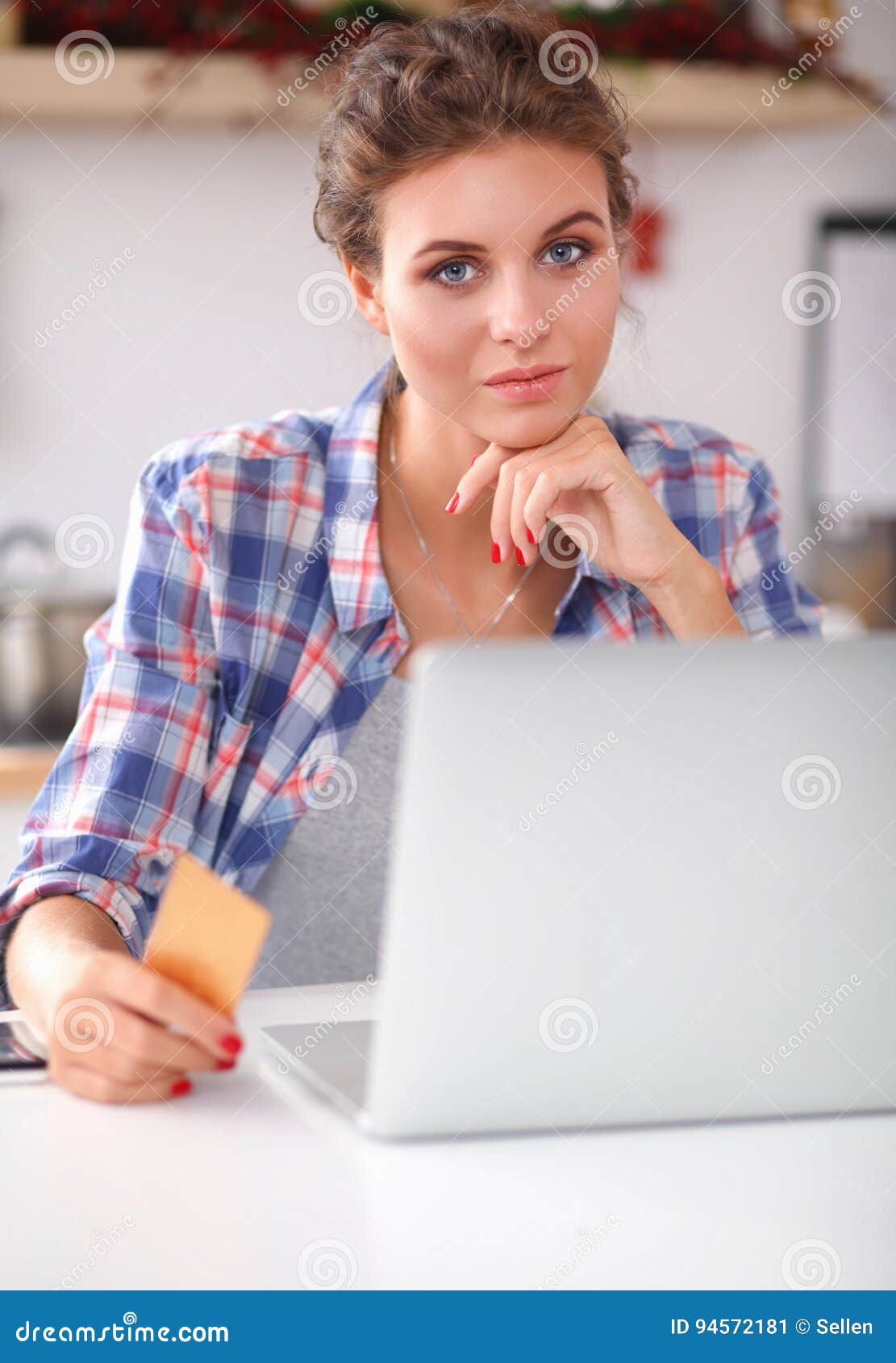 Smiling Woman Online Shopping Using Computer and Credit Card in Kitchen ...