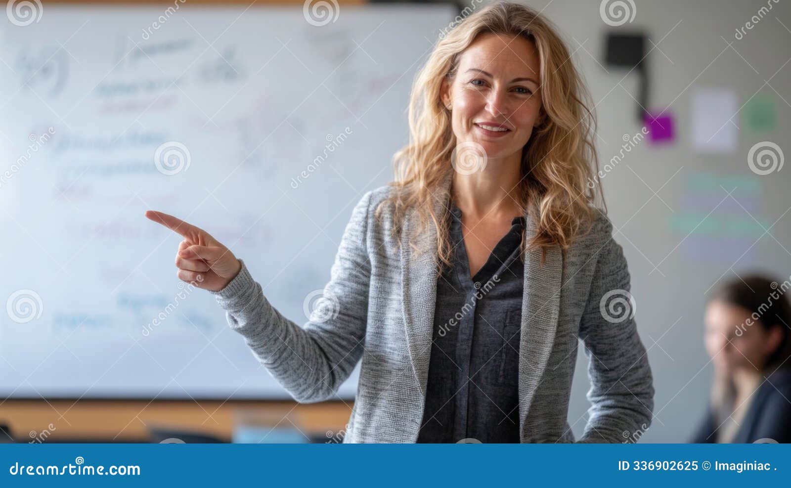 Smiling Woman Presenter Pointing at Whiteboard in Classroom Stock ...