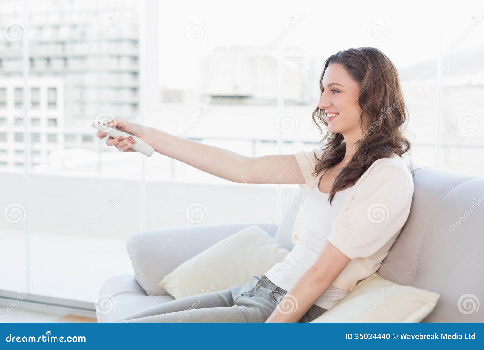 Smiling Woman with Remote Control Sitting on Sofa Stock Photo - Image ...