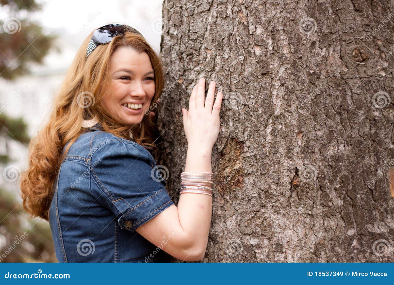 A smiling woman by a tree stock image. Image of dark - 18537349