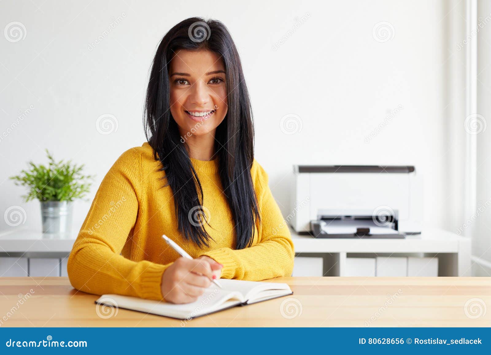 Smiling woman writes notes stock photo. Image of adult - 80628656