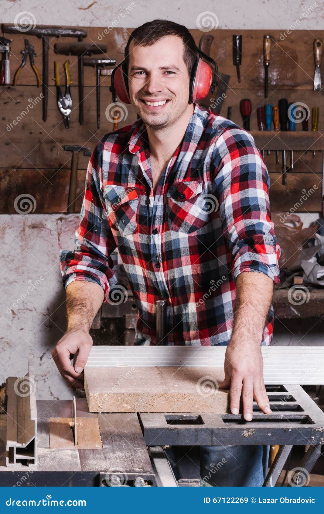 Smiling Woodworker. Cheerful Young Male Carpenter Leaning at the ... Smiling Woodworker. Cheerful Young Male Carpenter Leaning at the ...