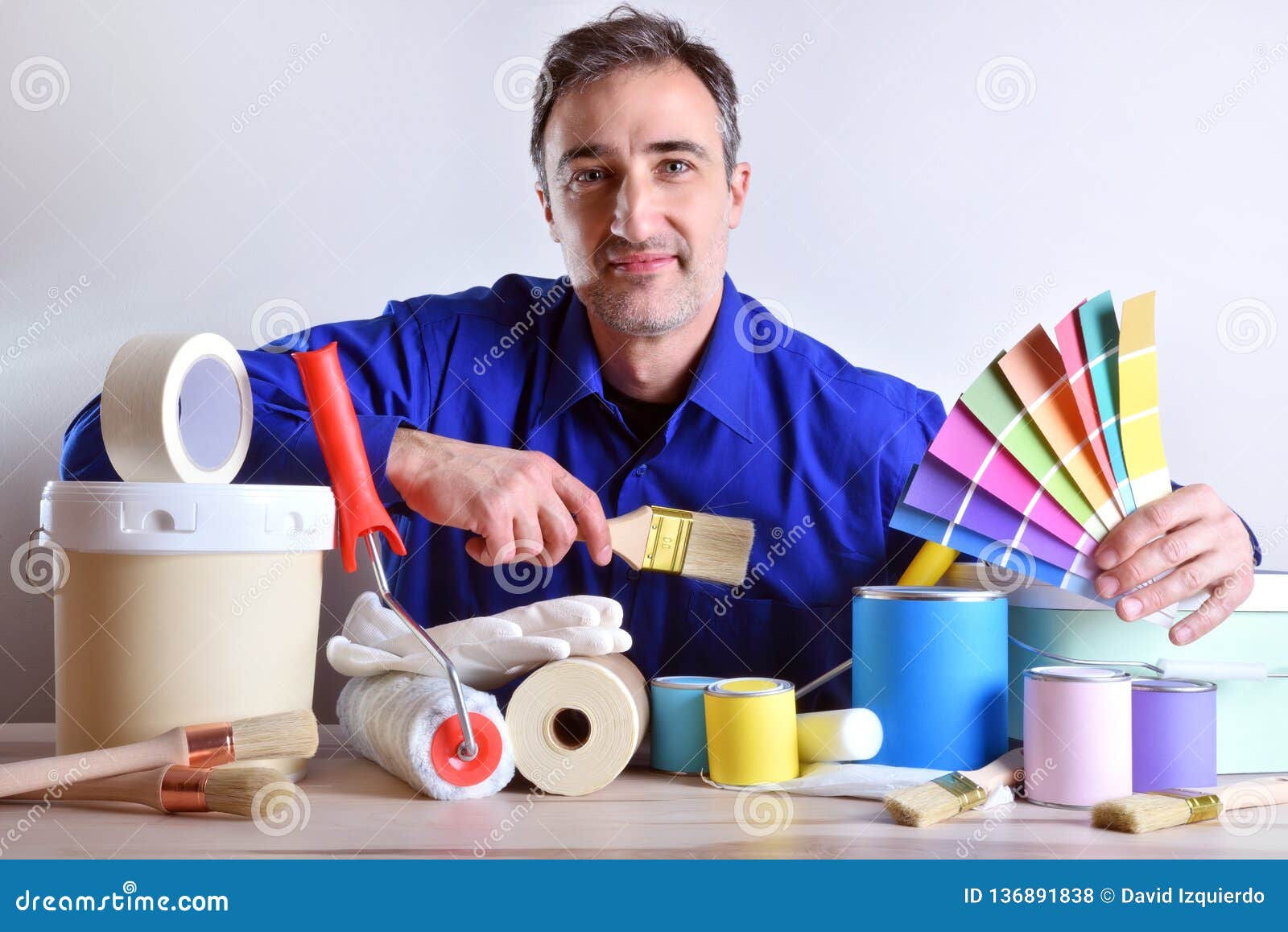 Smiling Worker Presenting Painting Tools and Products on Table Stock ...