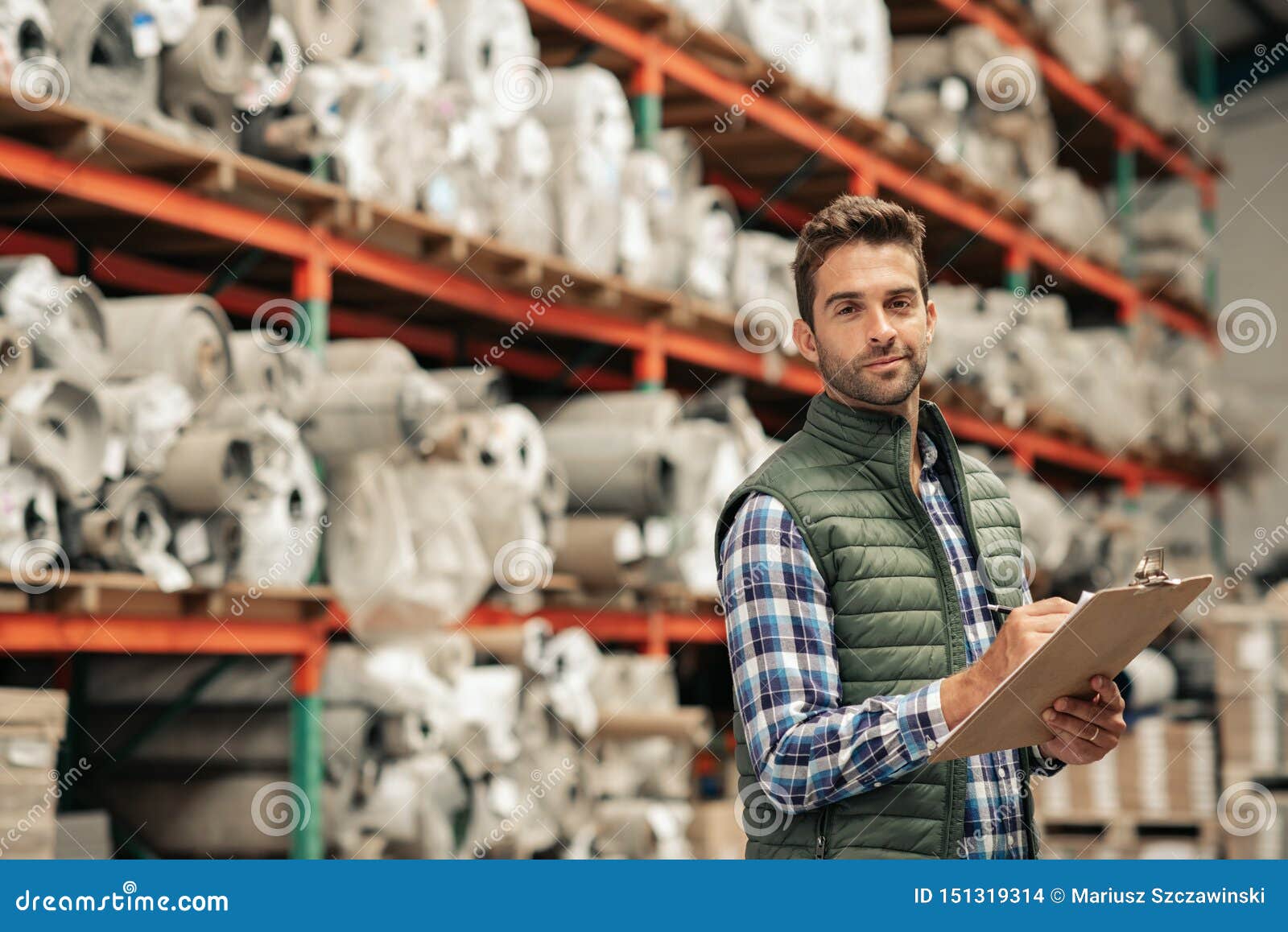 Smiling Worker Standing on a Warehouse Floor Doing Inventory Stock ...