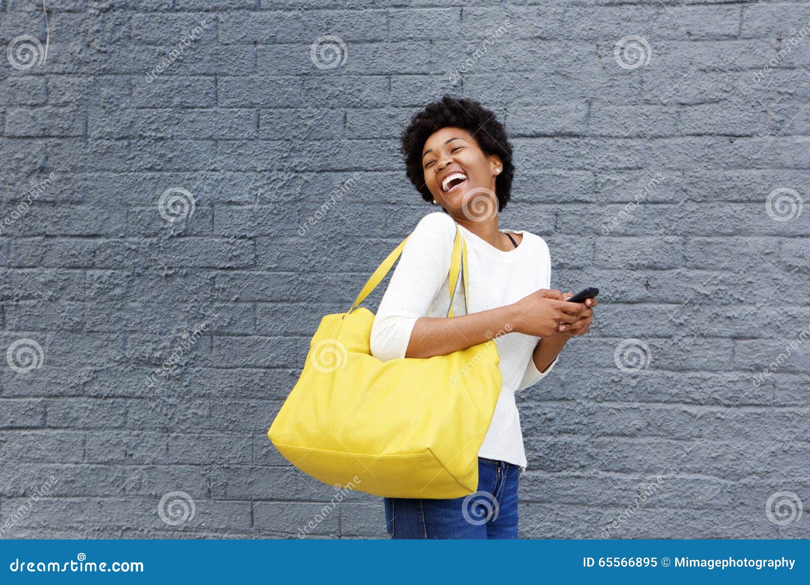 Smiling Young African Woman With Mobile Phone Looking Away Stock Image
