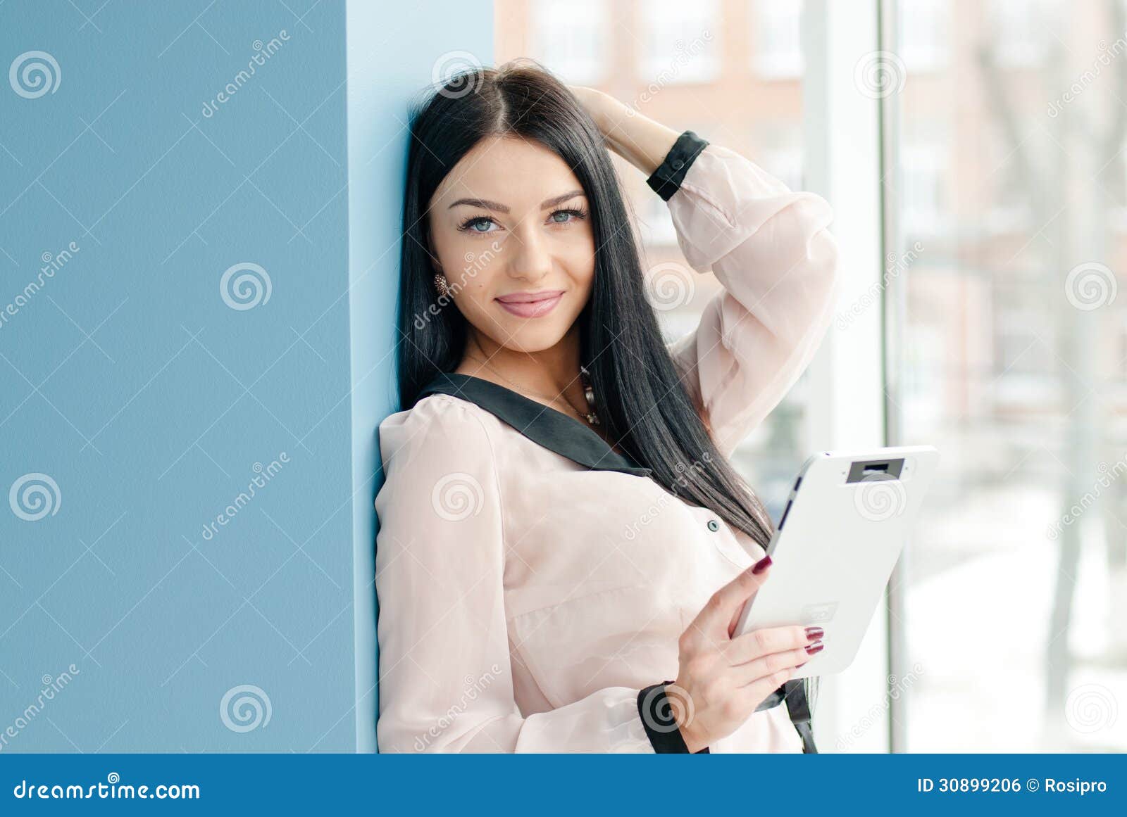 Smiling Young Business Woman Using Tablet PC while Standing Relaxed ... Smiling Young Business Woman Using Tablet PC while Standing Relaxed ...