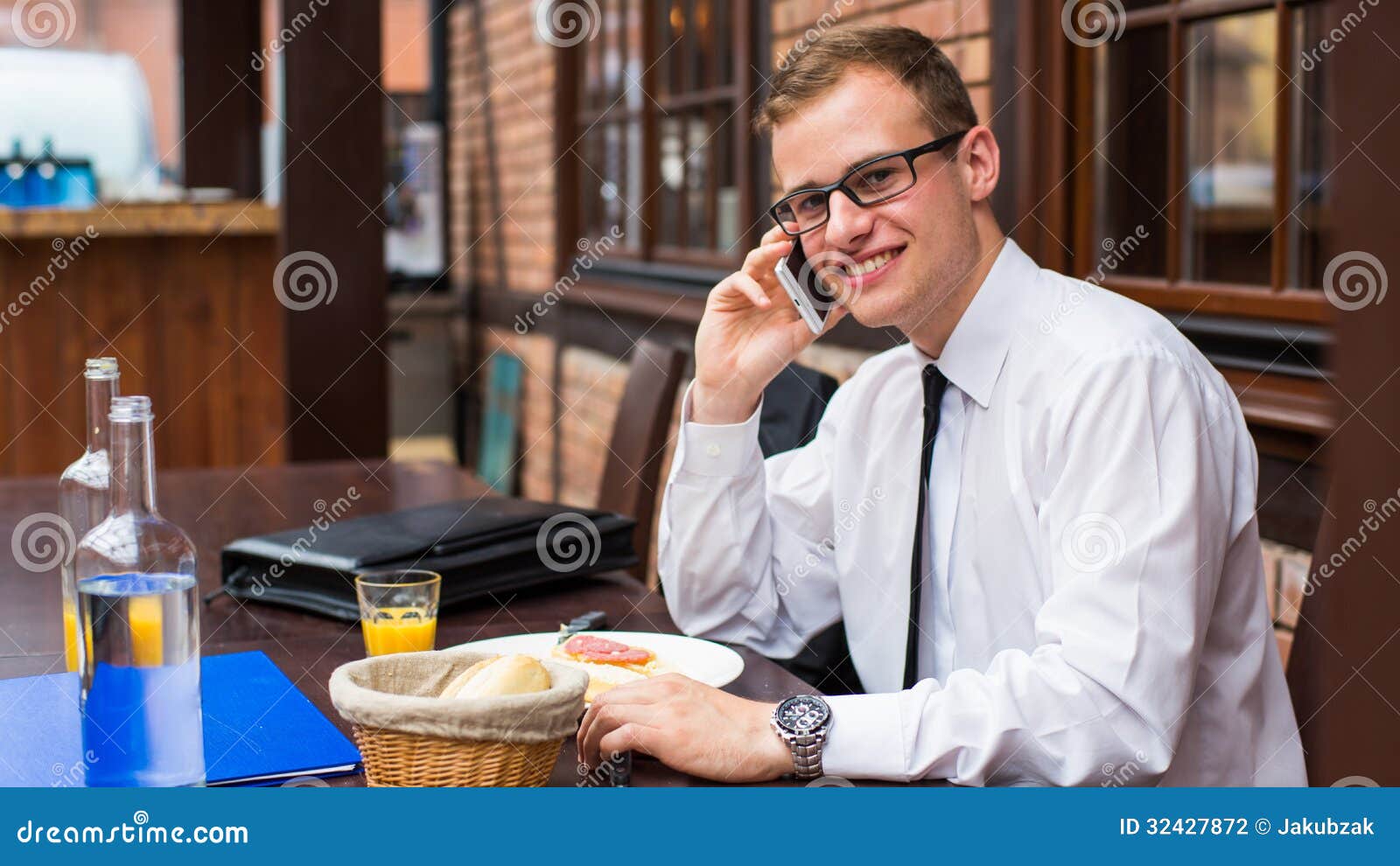 Smiling Young Businessman Making a Call with His Smartphone in a ...