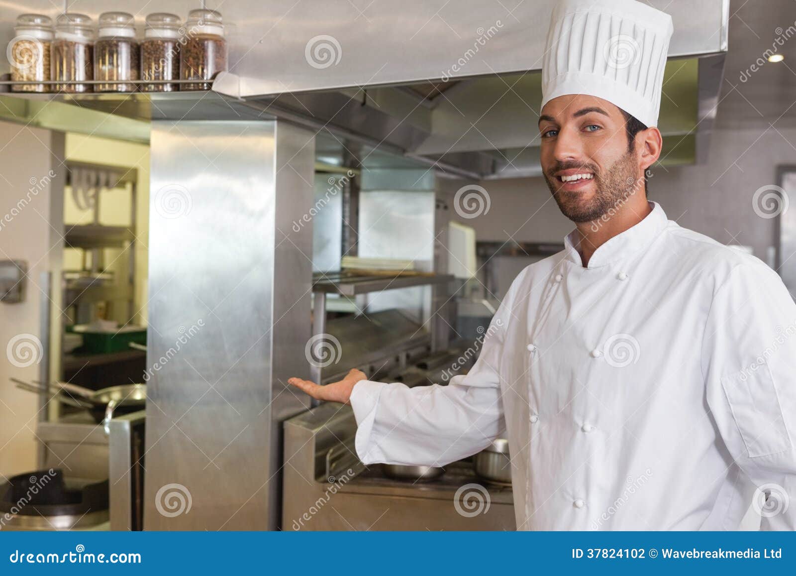 Smiling Young Chef Looking at Camera Showing His Workplace Stock Photo ...