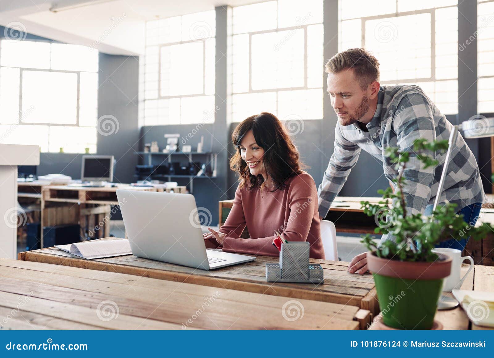 Smiling Young Colleagues Using a Laptop Together in an Office Stock ... Smiling Young Colleagues Using a Laptop Together in an Office Stock ...