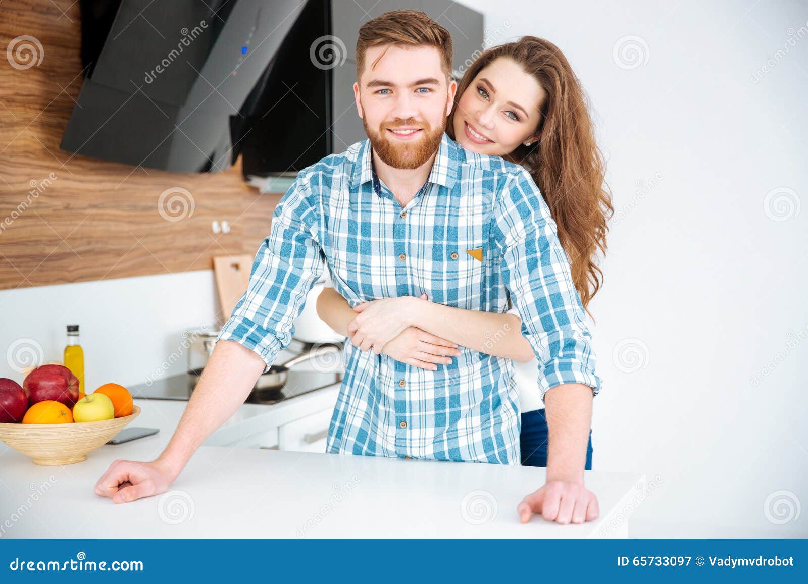 Smiling Young Couple Hugging in the Kitchen Stock Image - Image of ...