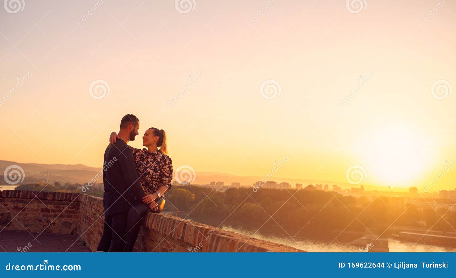 Smiling Couple Hugging at Sunset Stock Photo - Image of caucasian ...