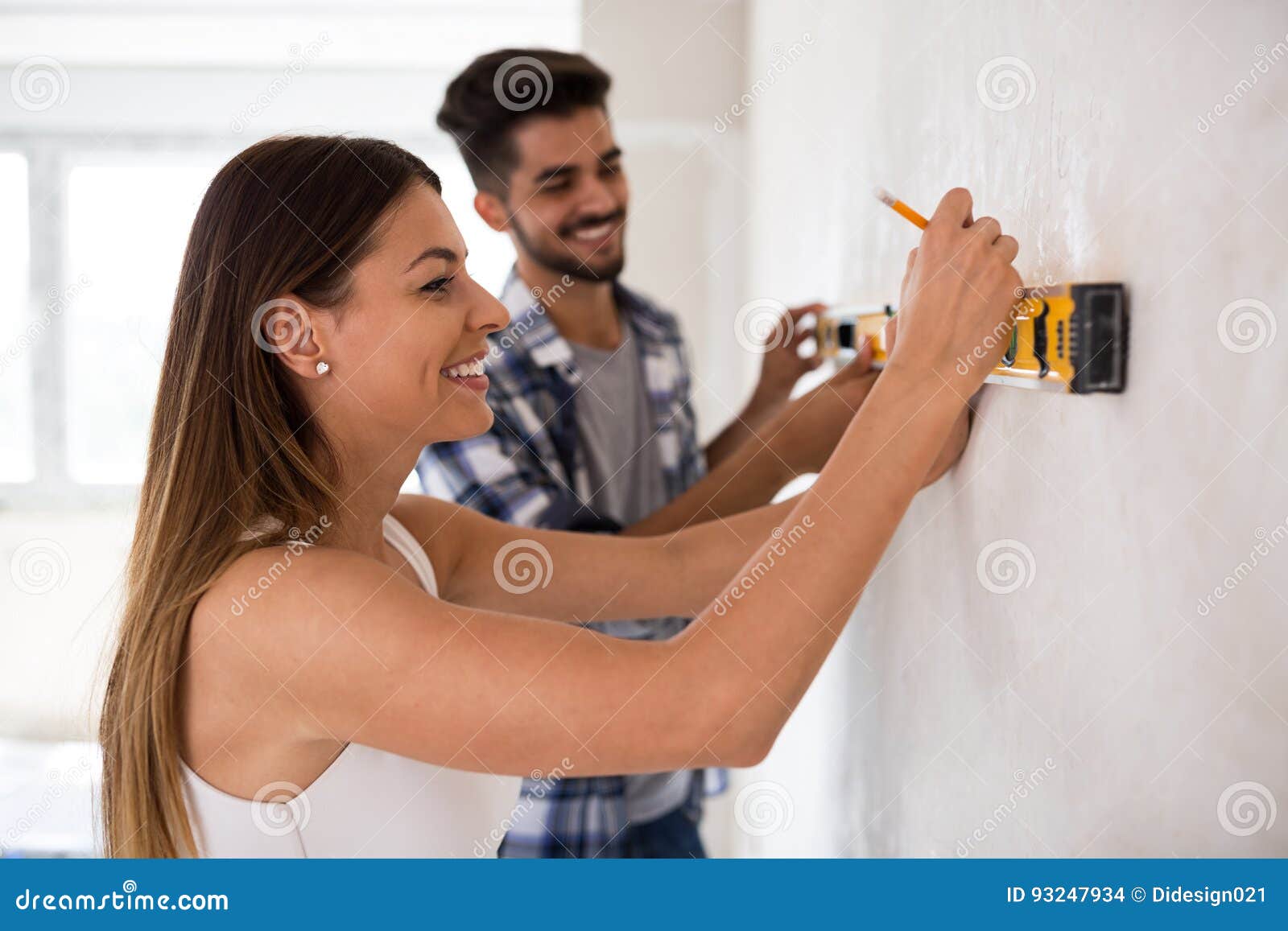 Smiling Young Couple Measuring Wall with Level Tool, Renovation Stock ...
