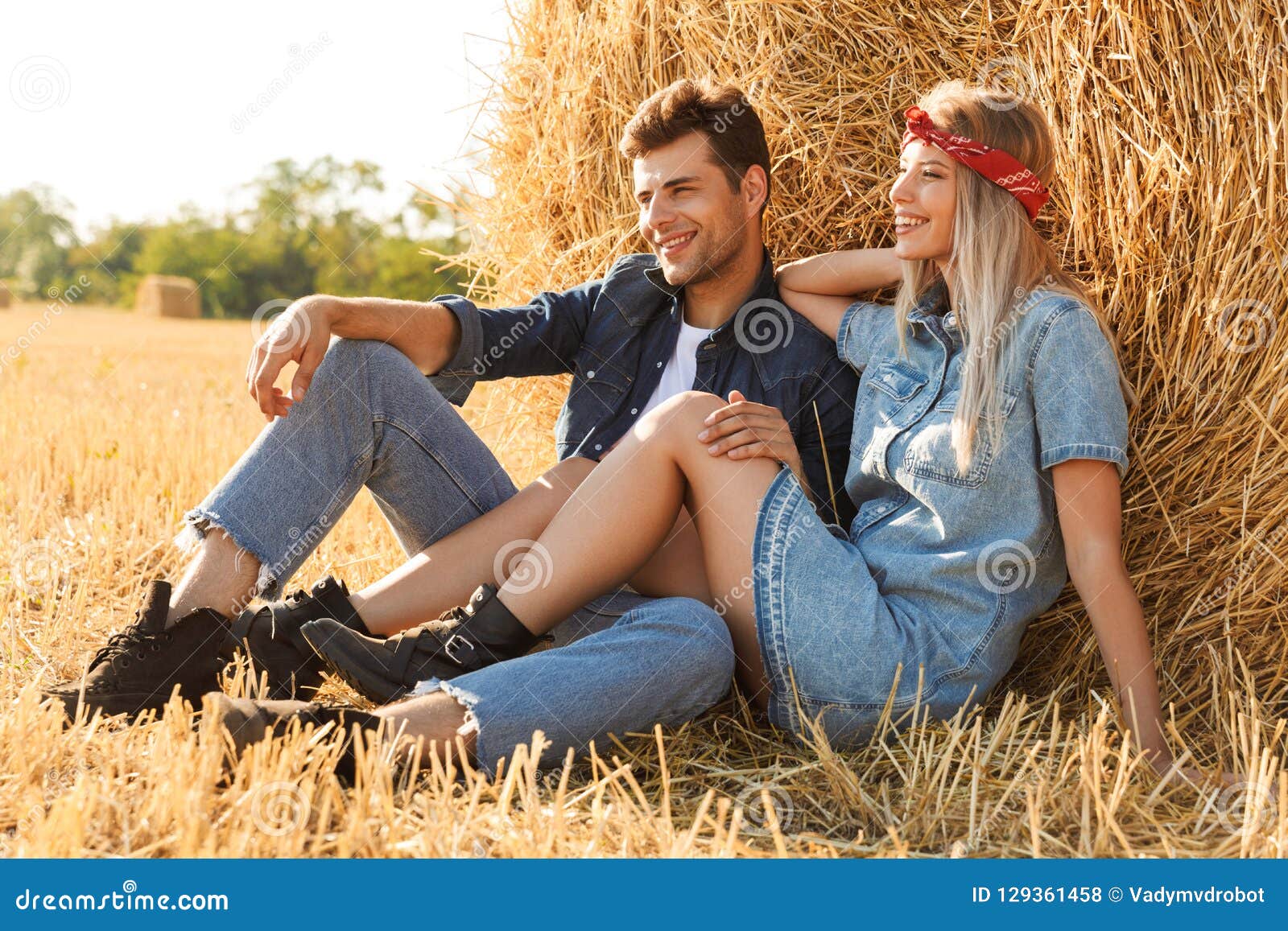 Smiling Young Couple Sitting Together at a Haystack Stock Photo - Image ...
