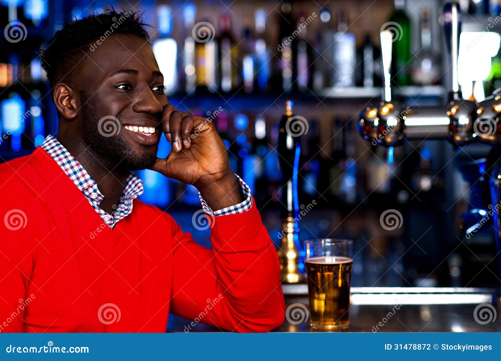 Smiling Young Guy in Bar Looking at Something Stock Photo - Image of ...