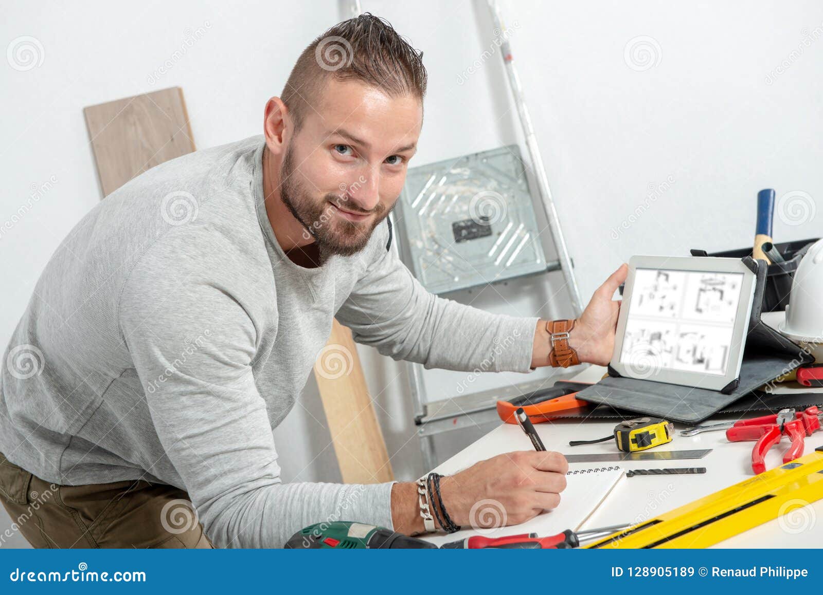 Smiling Young Handyman Using Computer Tablet, DIY at Home Stock Image ...