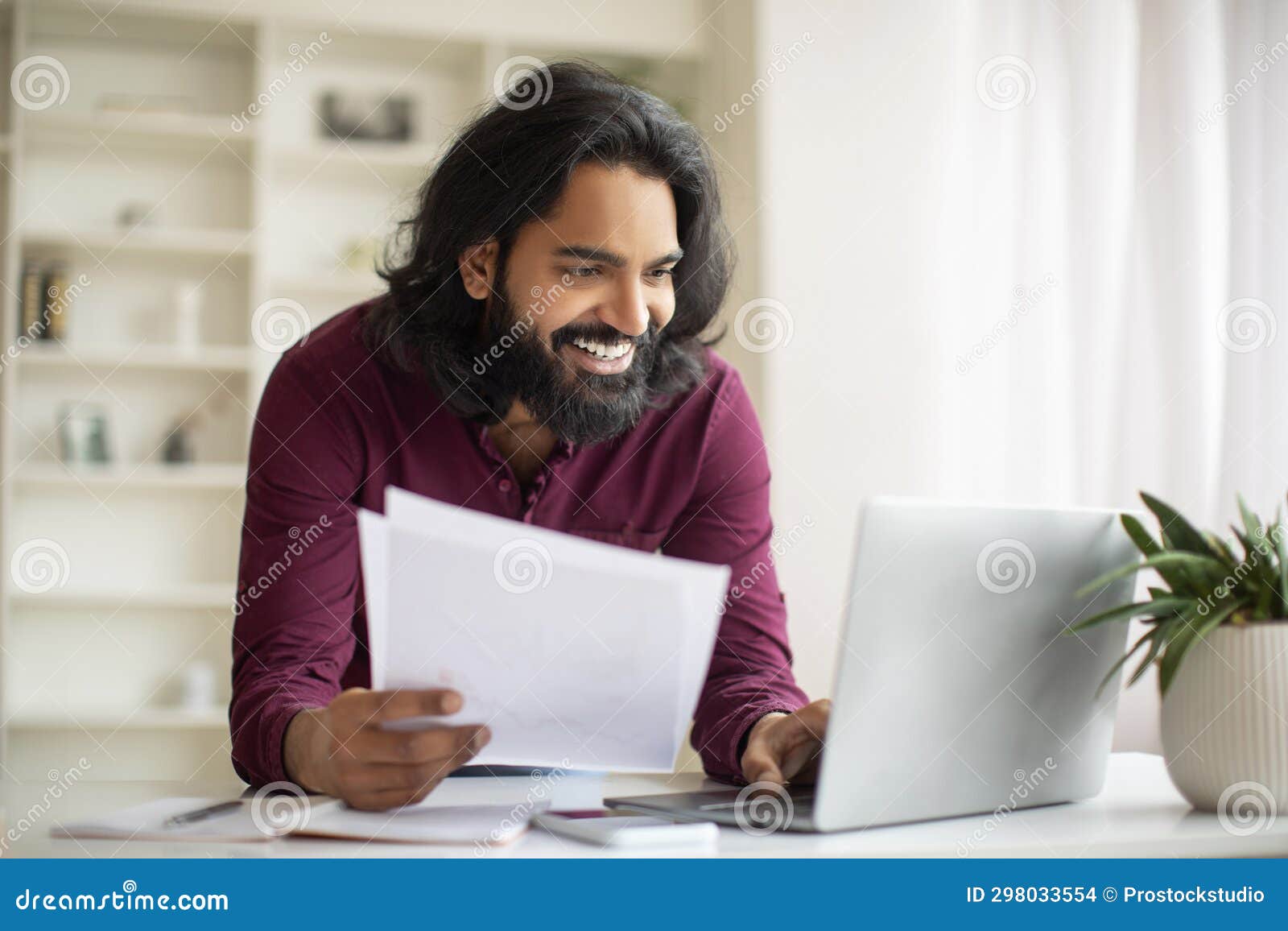 Smiling Young Indian Man Working with Papers and Laptop at Home Office ...