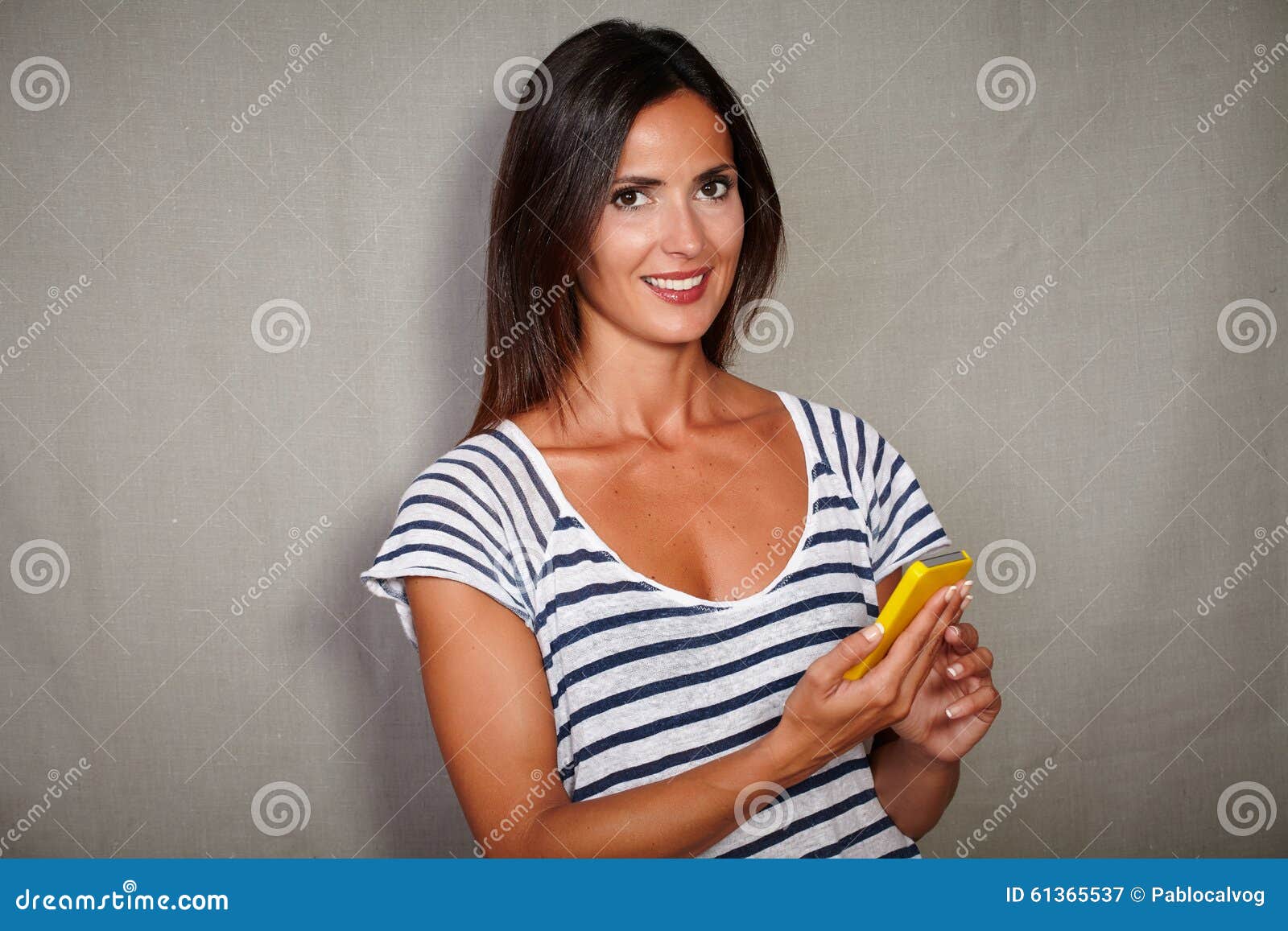Smiling Young Lady Holding Mobile Phone Stock Image - Image of brunette ...