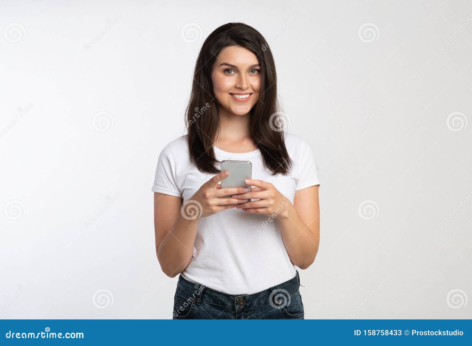 Smiling Young Lady Using Mobile Phone Standing in Studio Stock Image ...