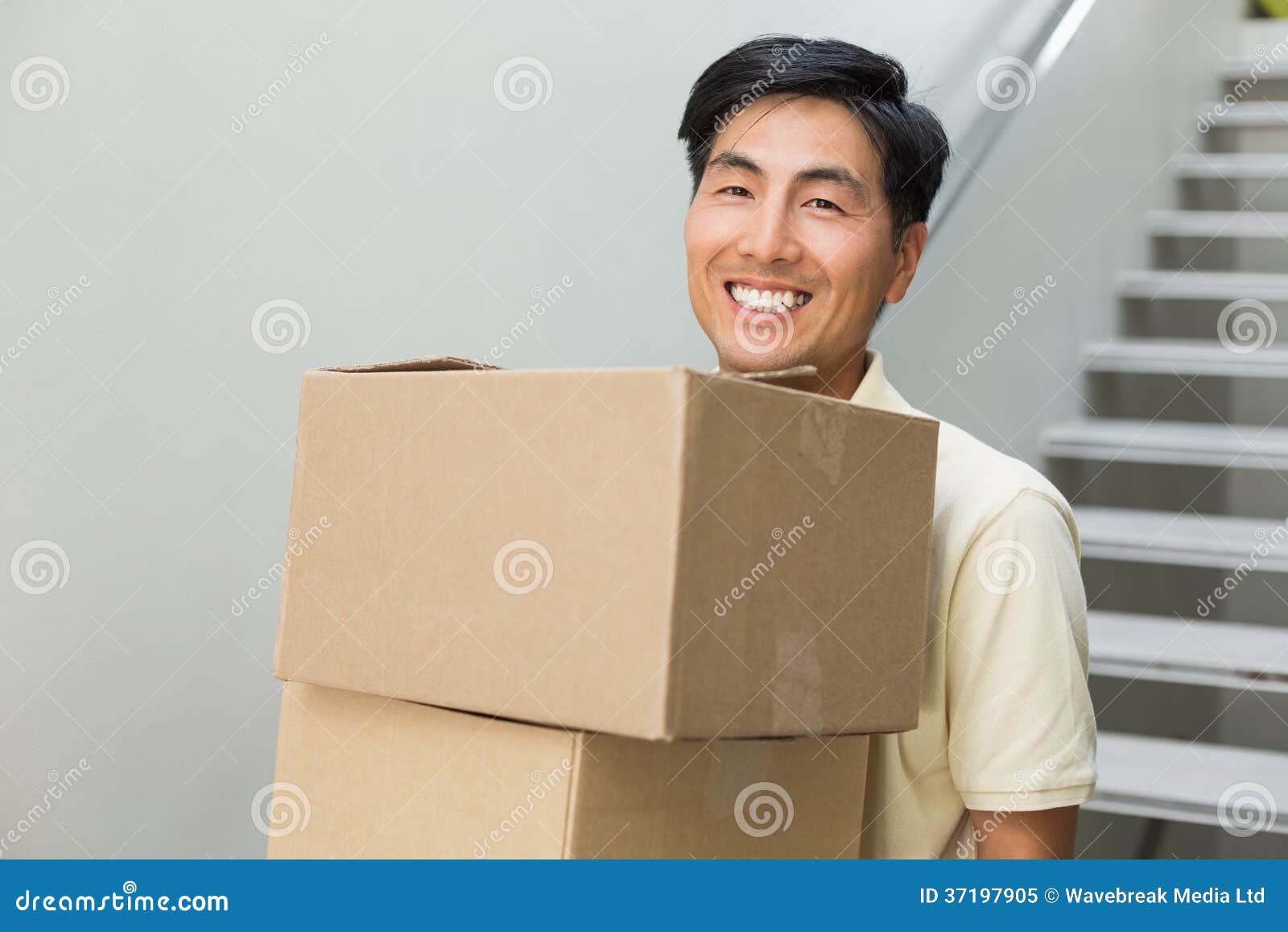 Smiling Young Man Carrying Boxes Against Staircase Stock Image - Image ...