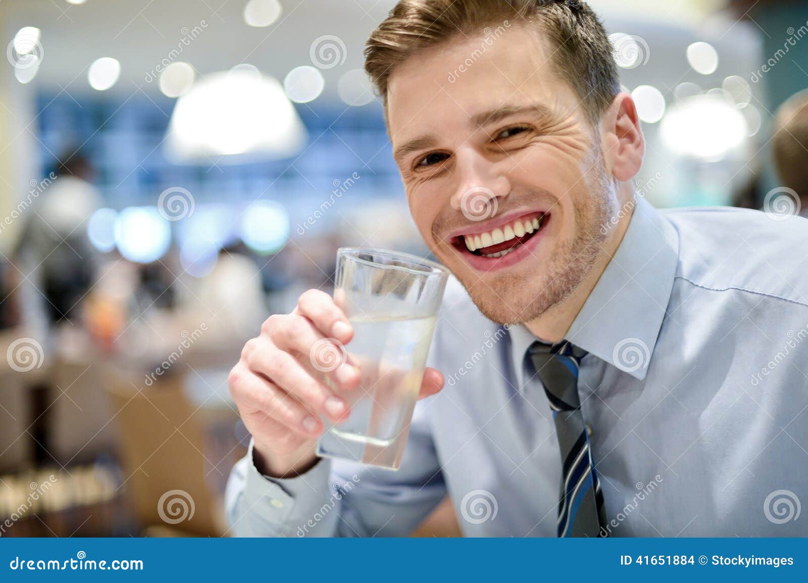 Smiling Young Man Drinking Water in Restaurant Stock Photo - Image of ...