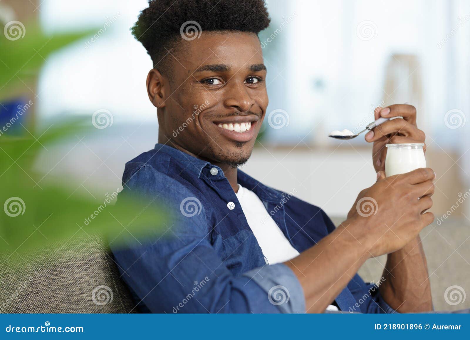 Smiling Young Man Eating Yogurt Stock Photo - Image of snack, smile ...