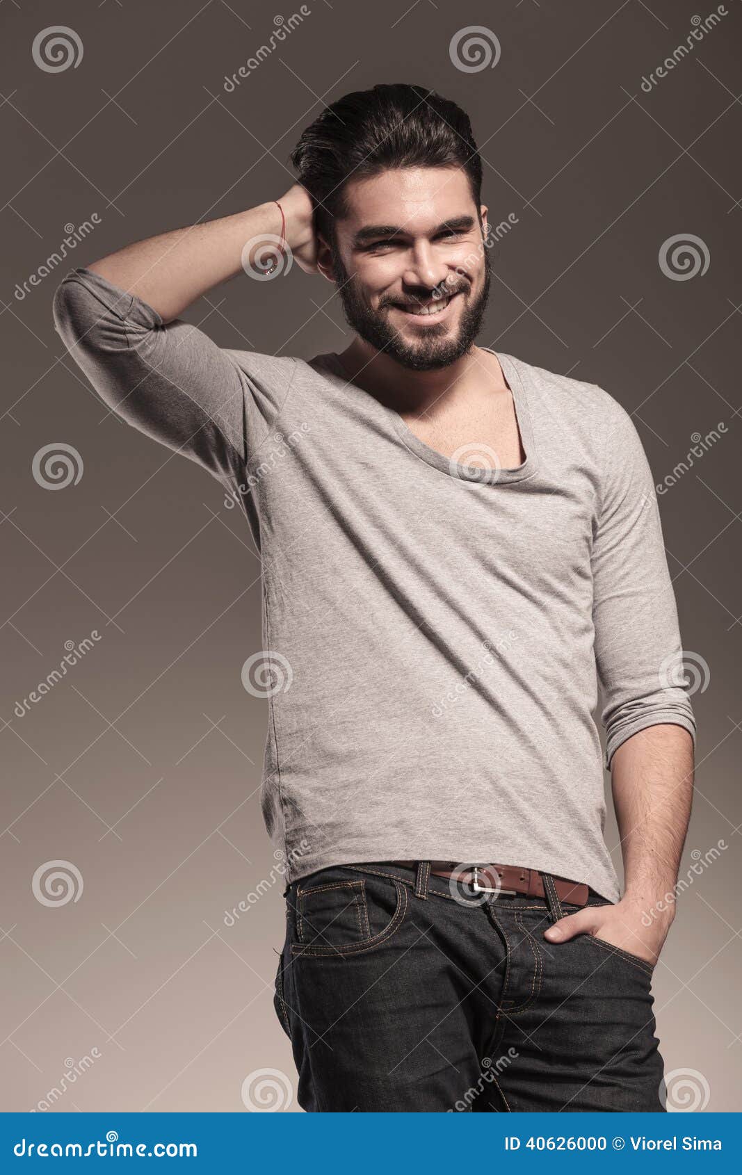 Smiling Young Man Fixing His Hair Stock Photo - Image of model, gray ...
