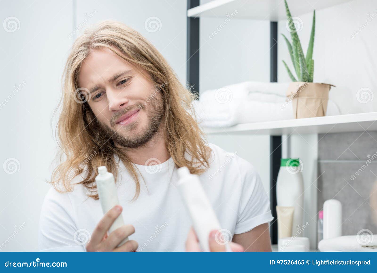 Smiling Young Man Holding Toothpaste while Standing in Bathroom Stock ...