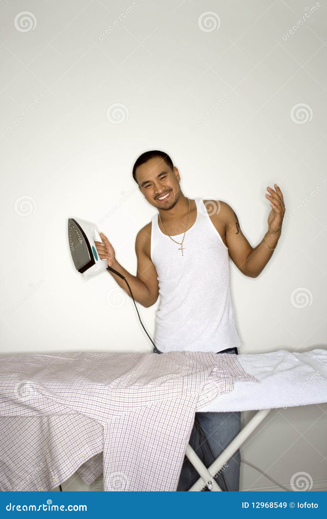 Smiling Young Man Ironing stock image. Image of board - 12968549
