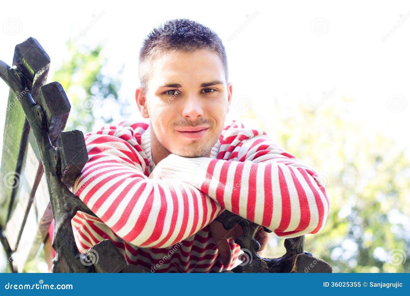 Smiling Young Man Lying and Resting on a Bench Stock Image - Image of ...