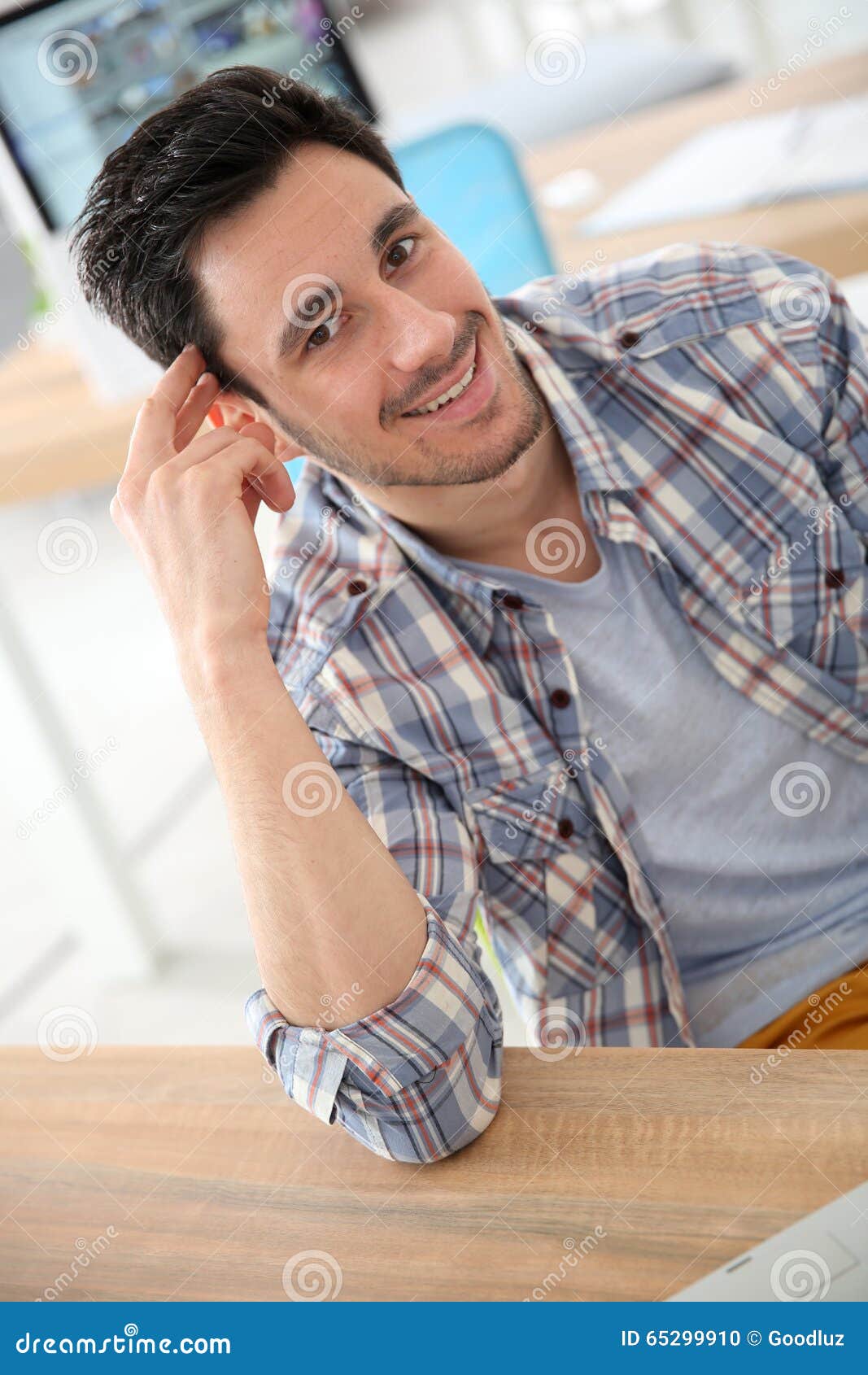 Smiling Young Man at Office Stock Photo - Image of casual, sitting ...