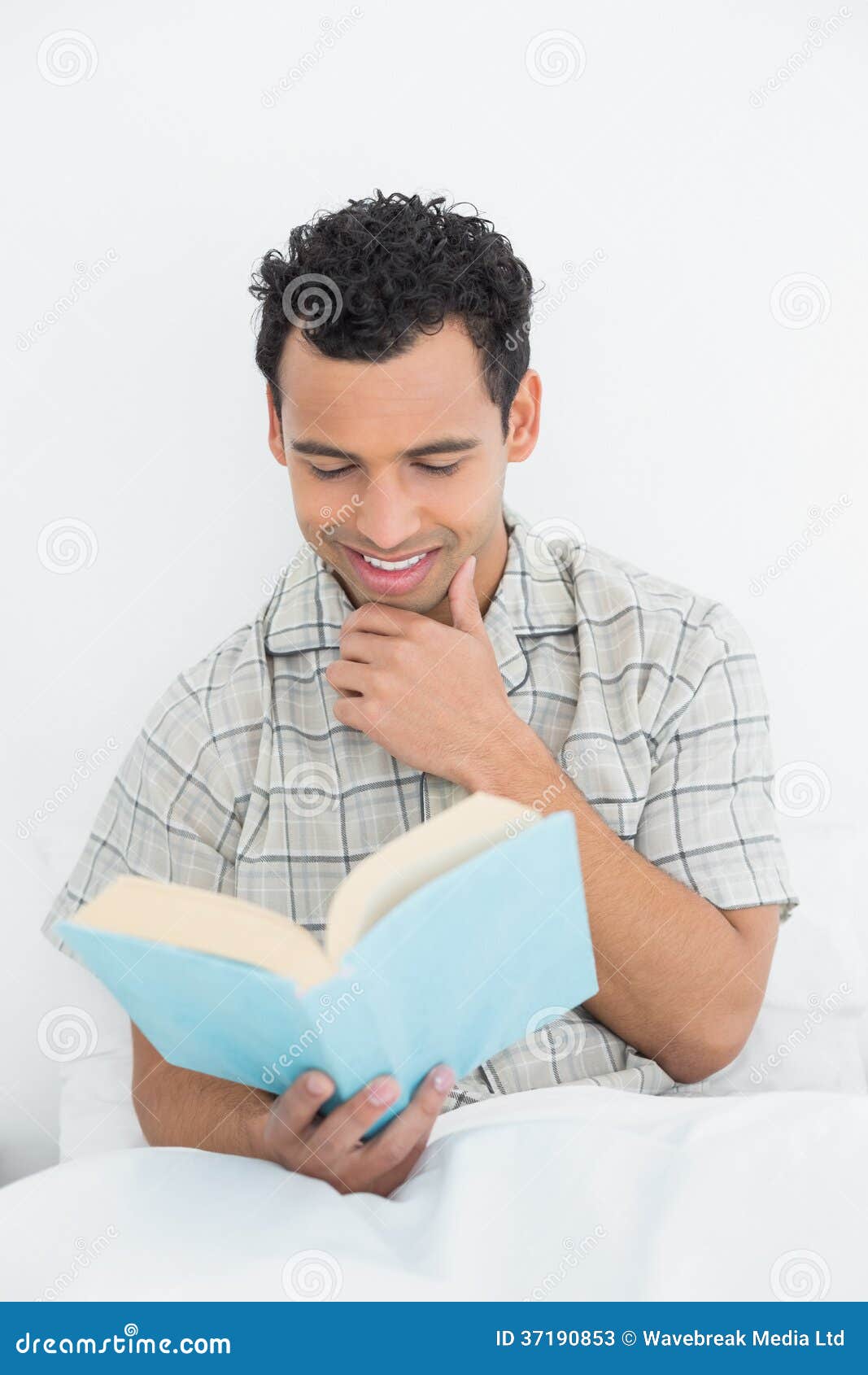 Smiling Young Man Reading Book in Bed Stock Image - Image of casual ...