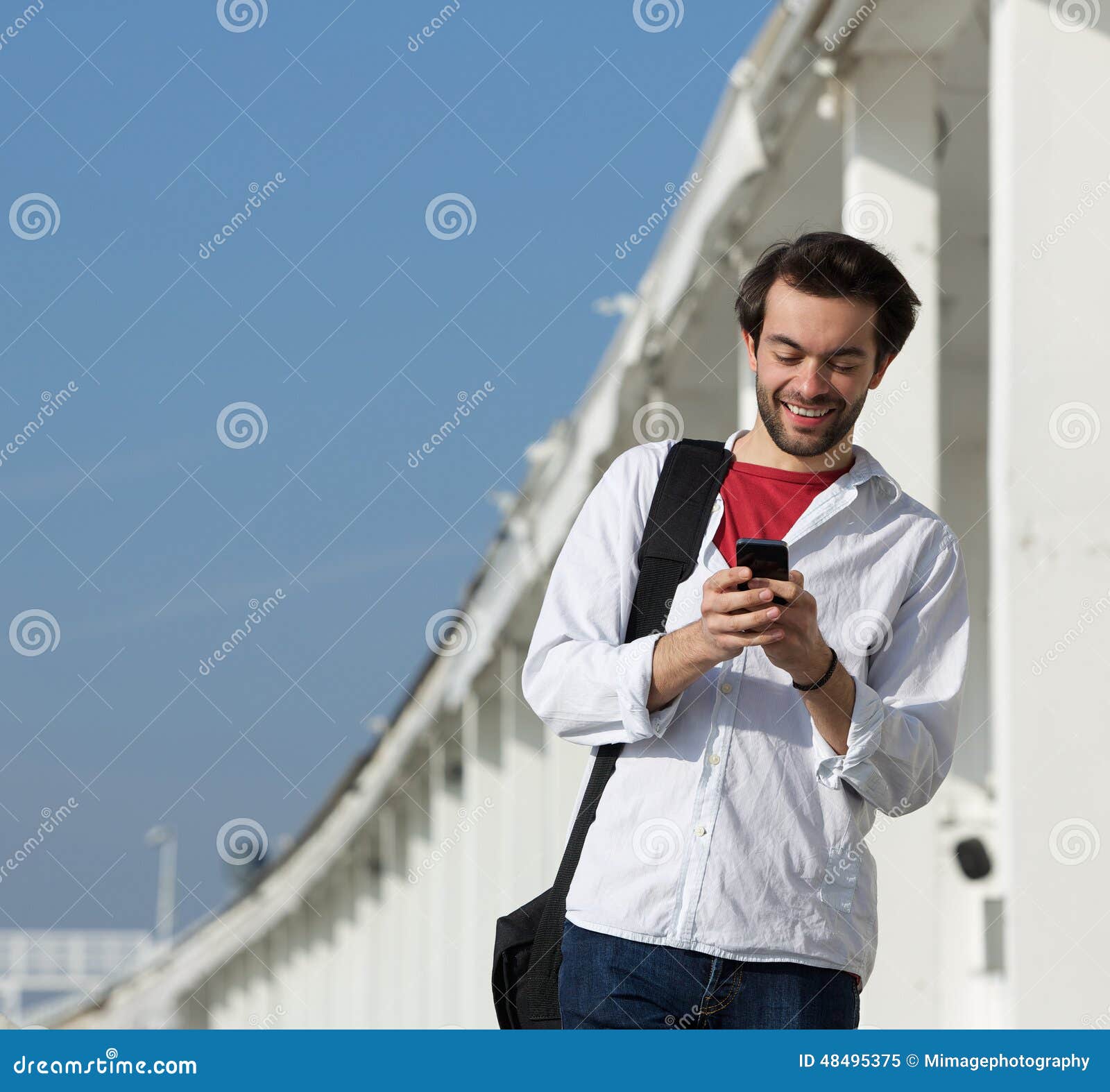 Smiling Young Man Reading Text Message on Mobile Phone Stock Image ...
