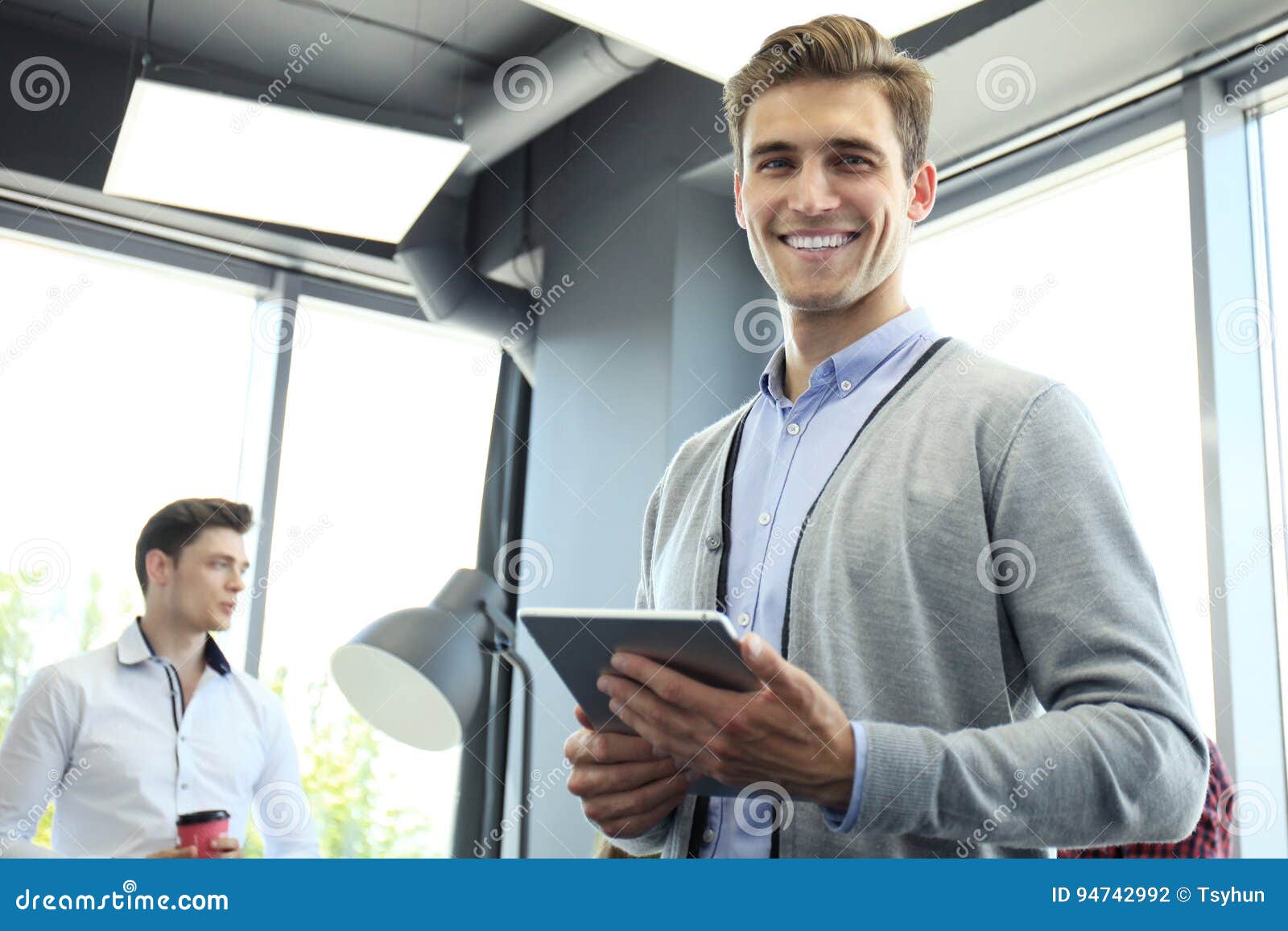 Smiling Young Man Using Digital Tablet in the Office. Stock Photo ...
