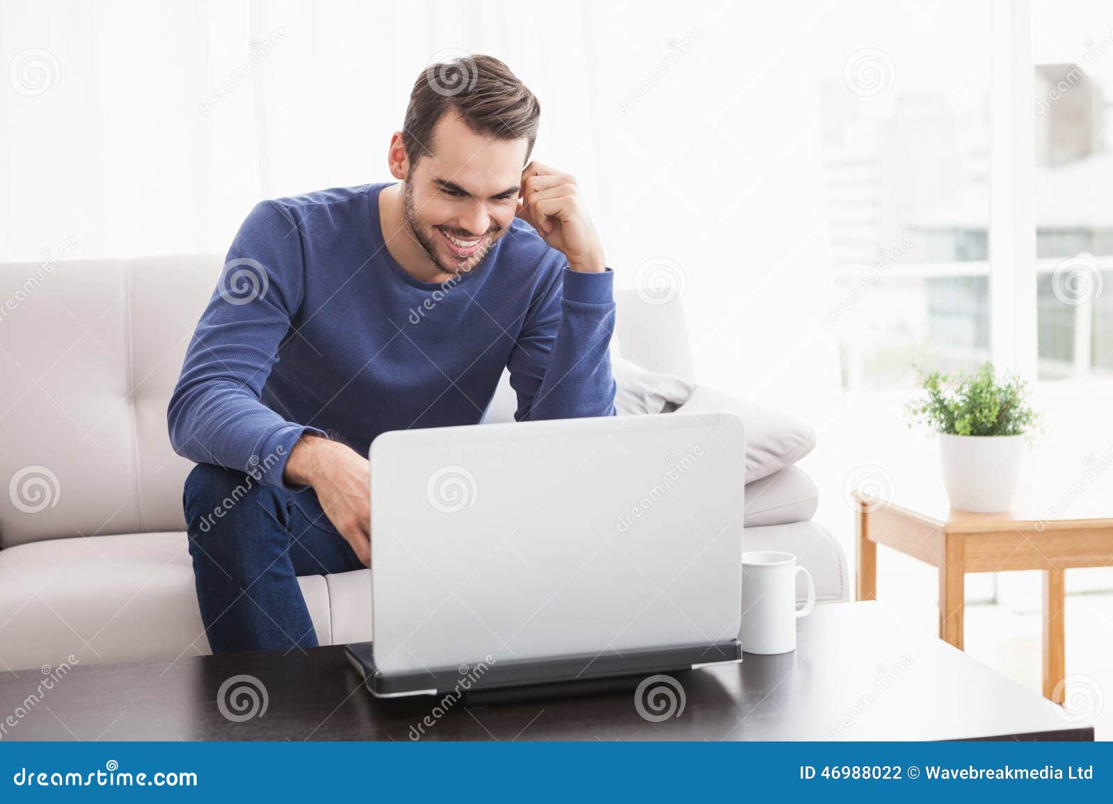 Smiling Young Man Using His Laptop Stock Photo - Image of sofa, laptop ...