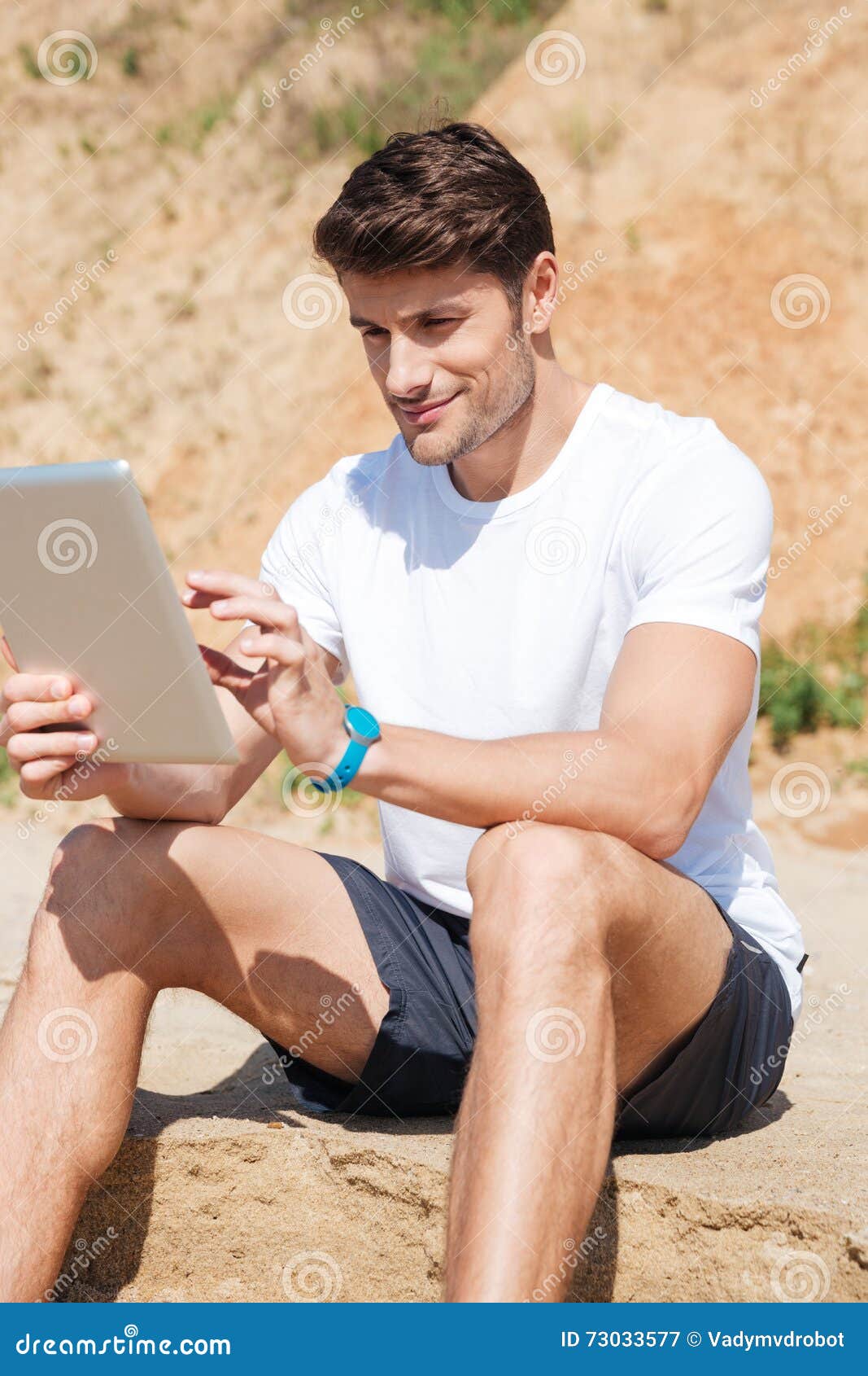 Smiling Young Man Using Tablet on the Beach Stock Image - Image of ...