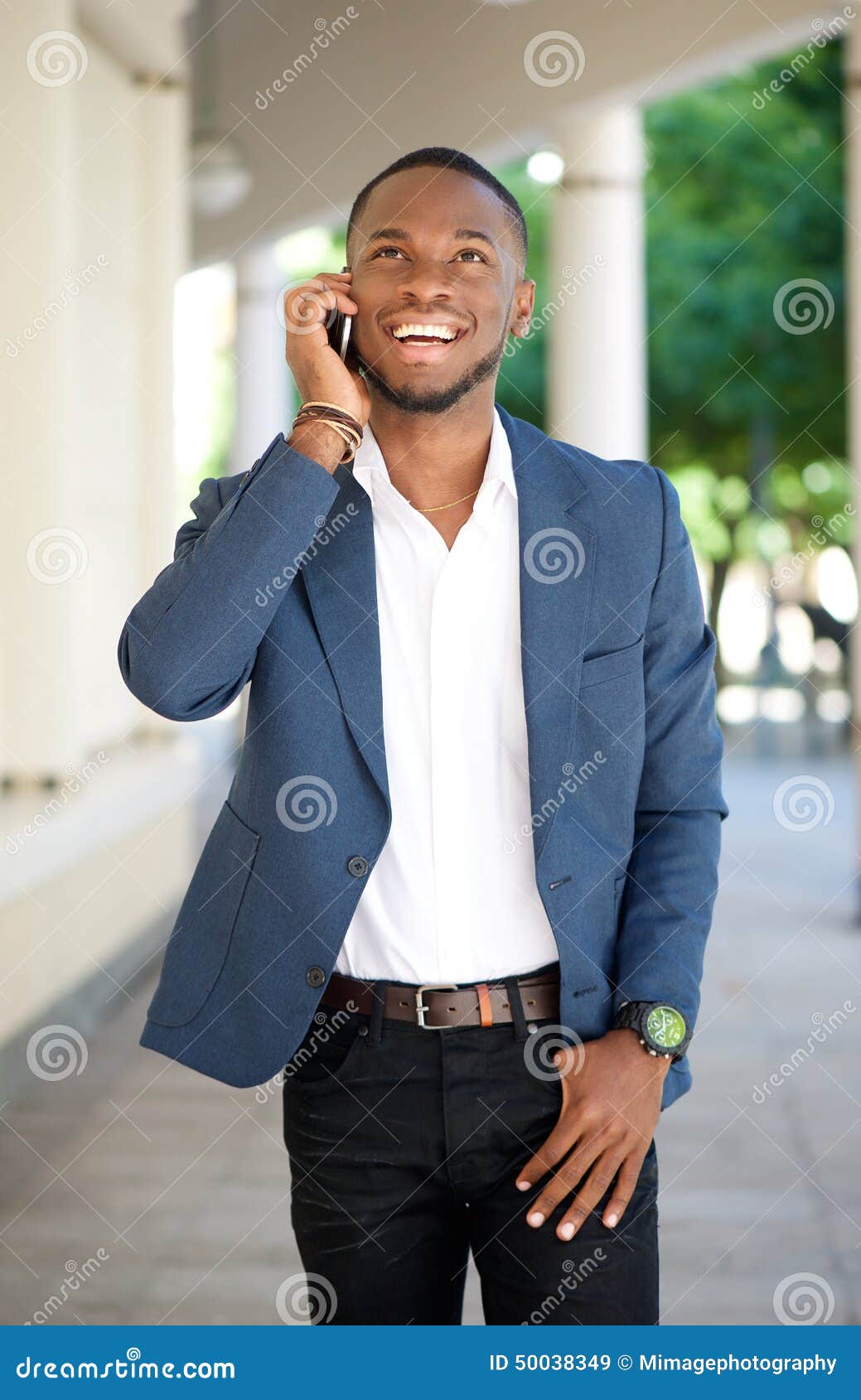 Smiling Young Man Walking and Talking by Mobile Phone Stock Image ...