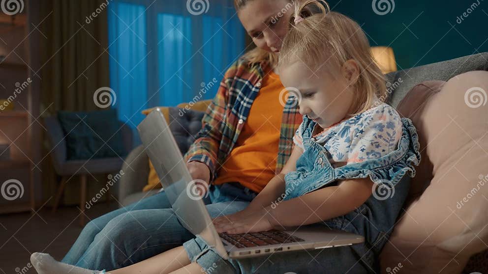 Smiling Young Mom Teaching Her Daughter How To Use Computer