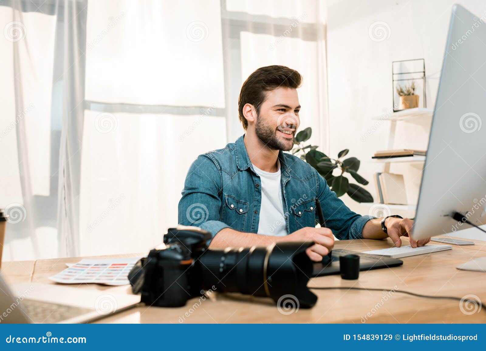 Smiling Young Photographer Using Desktop Computer and Retouching Photos ...