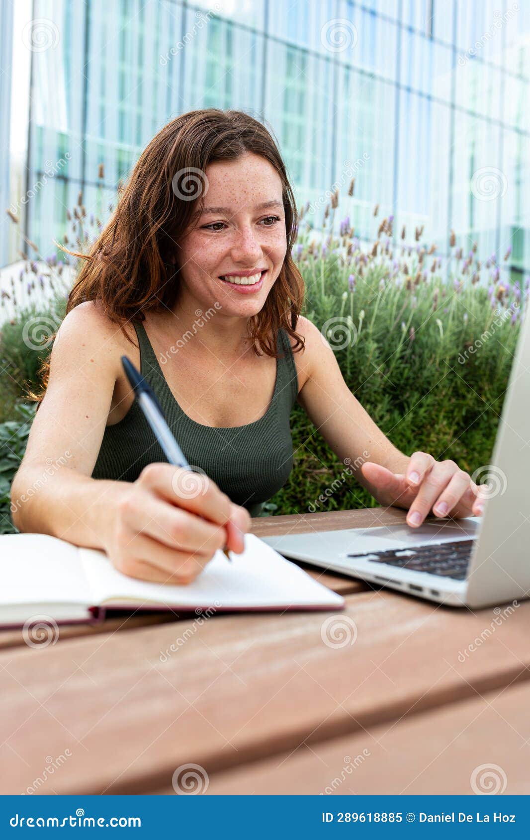Smiling Female University Student Writing on Notebook with Pen while ...