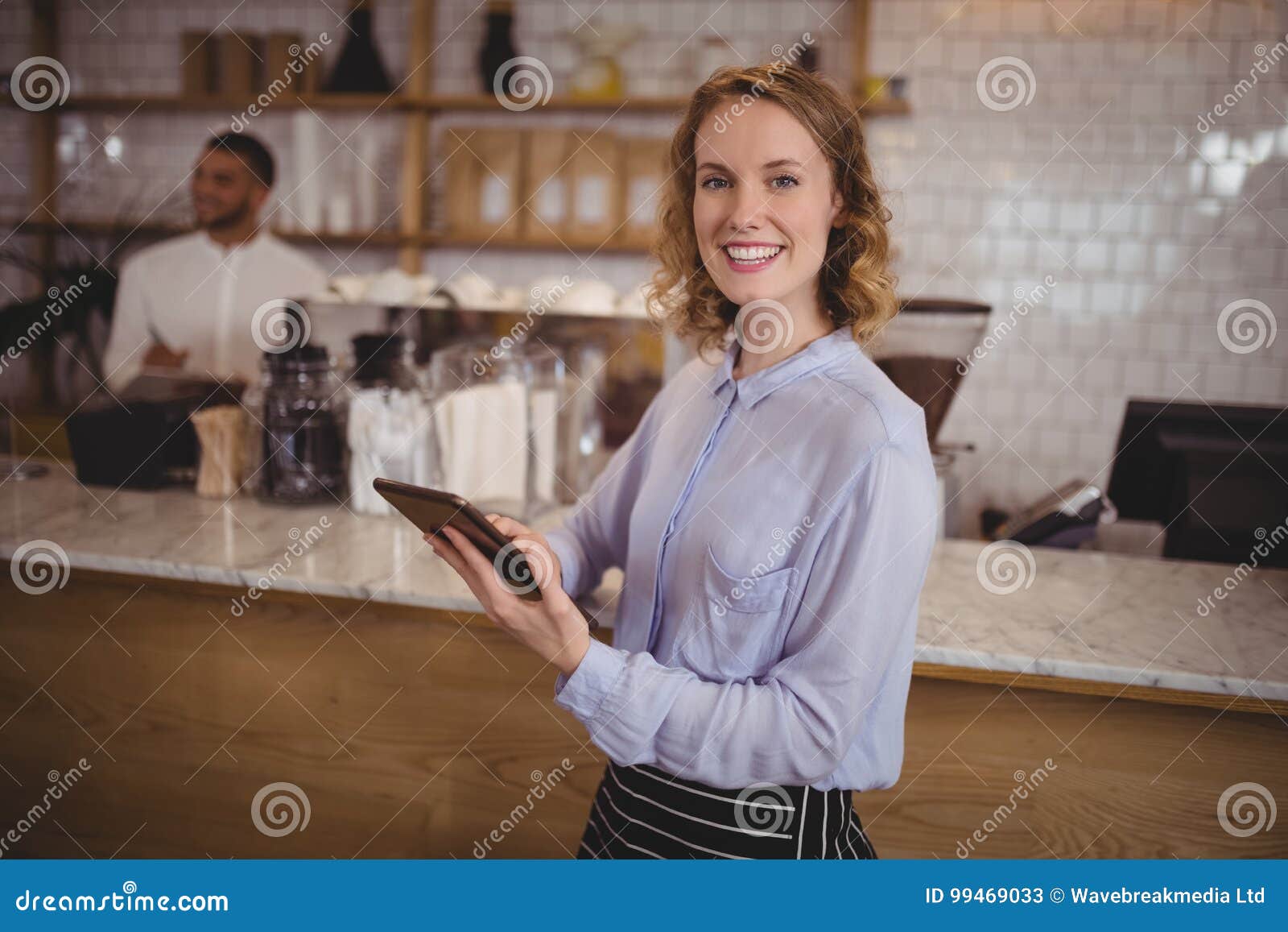 Smiling Young Waitress Using Digital Tablet while Standing by Counter ...