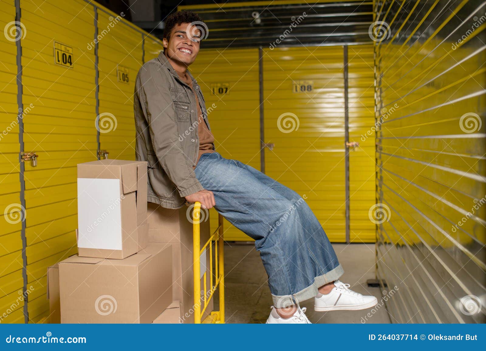 Smiling Young Warehouse Worker Sitting on the Box and Resting Stock ...