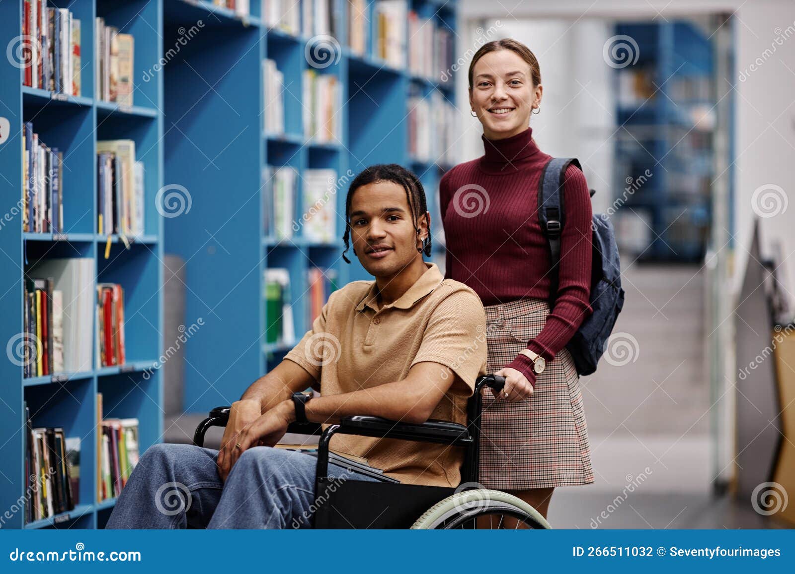 Smiling Young Woman Assisting Student with Disability in Library Stock ...