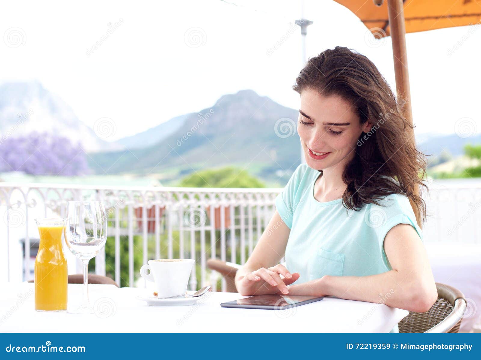 Smiling Young Woman Sitting At Outdoor Cafe With Digital Tablet Stock
