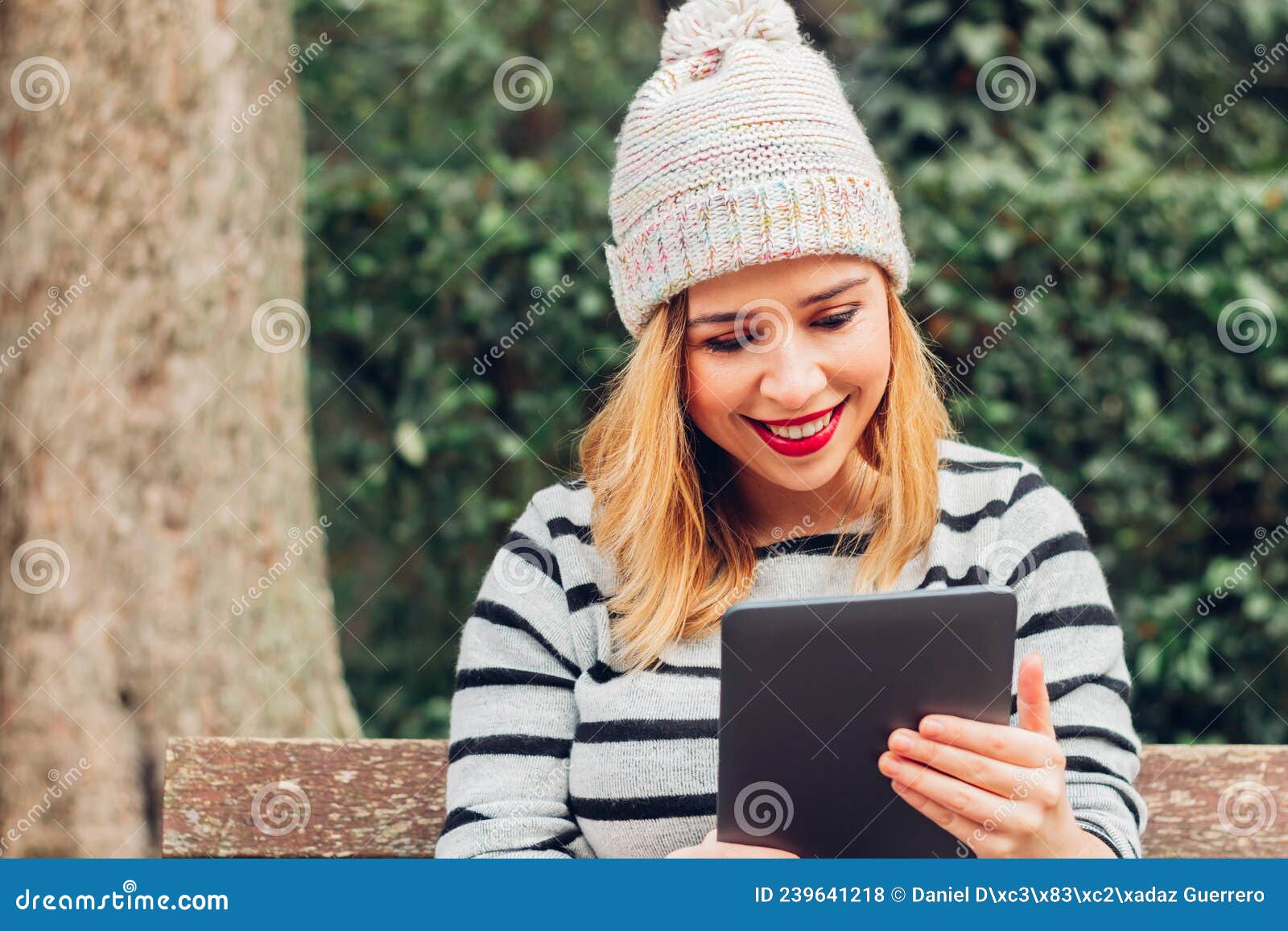 Smiling Young Woman Using Her Digital Tablet with a Happy and Amused ...